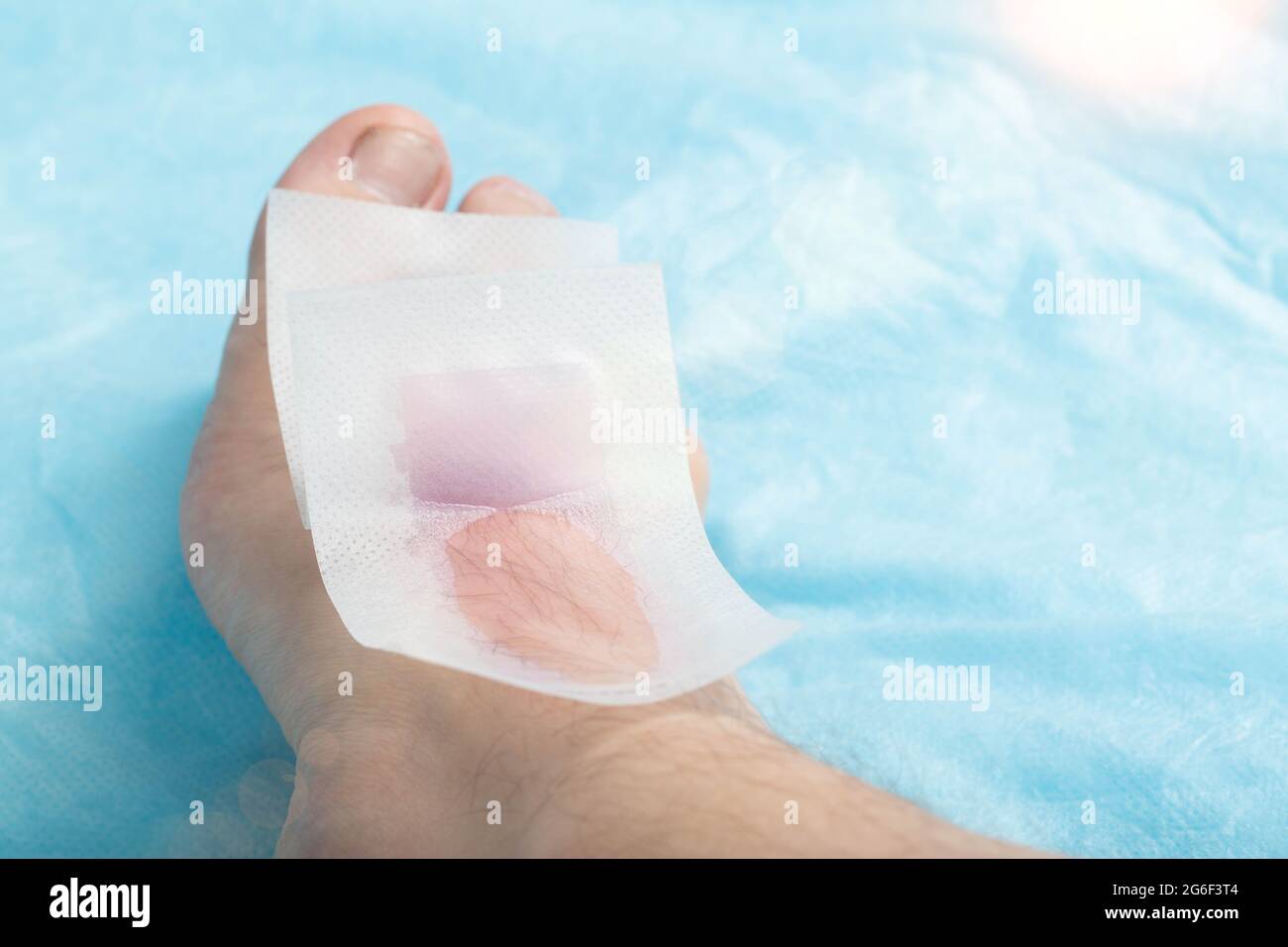 Depilatory wax strip for hair removal on human leg in beauty salon ...