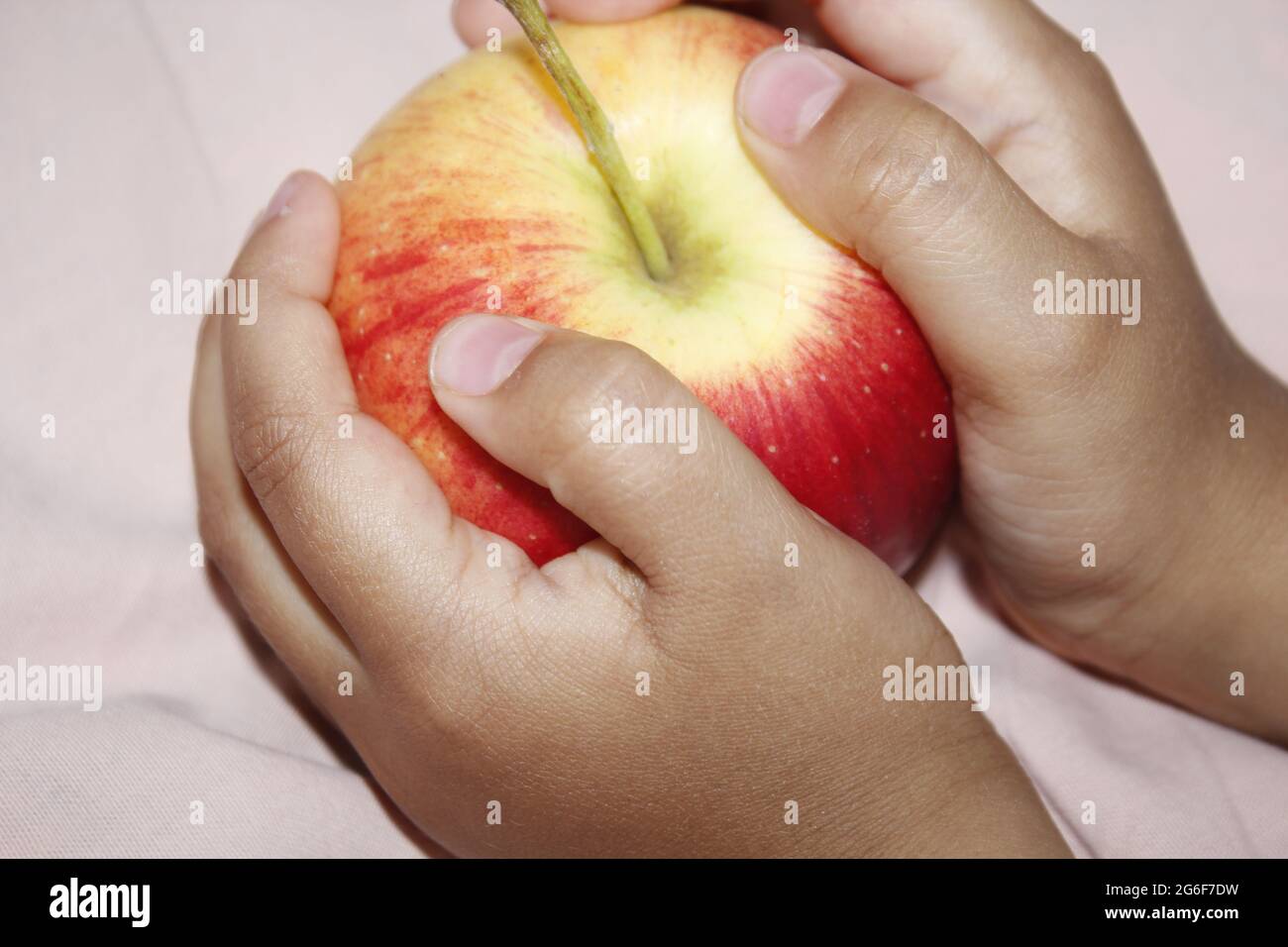 A little child eating a red apple Stock Photo - Alamy
