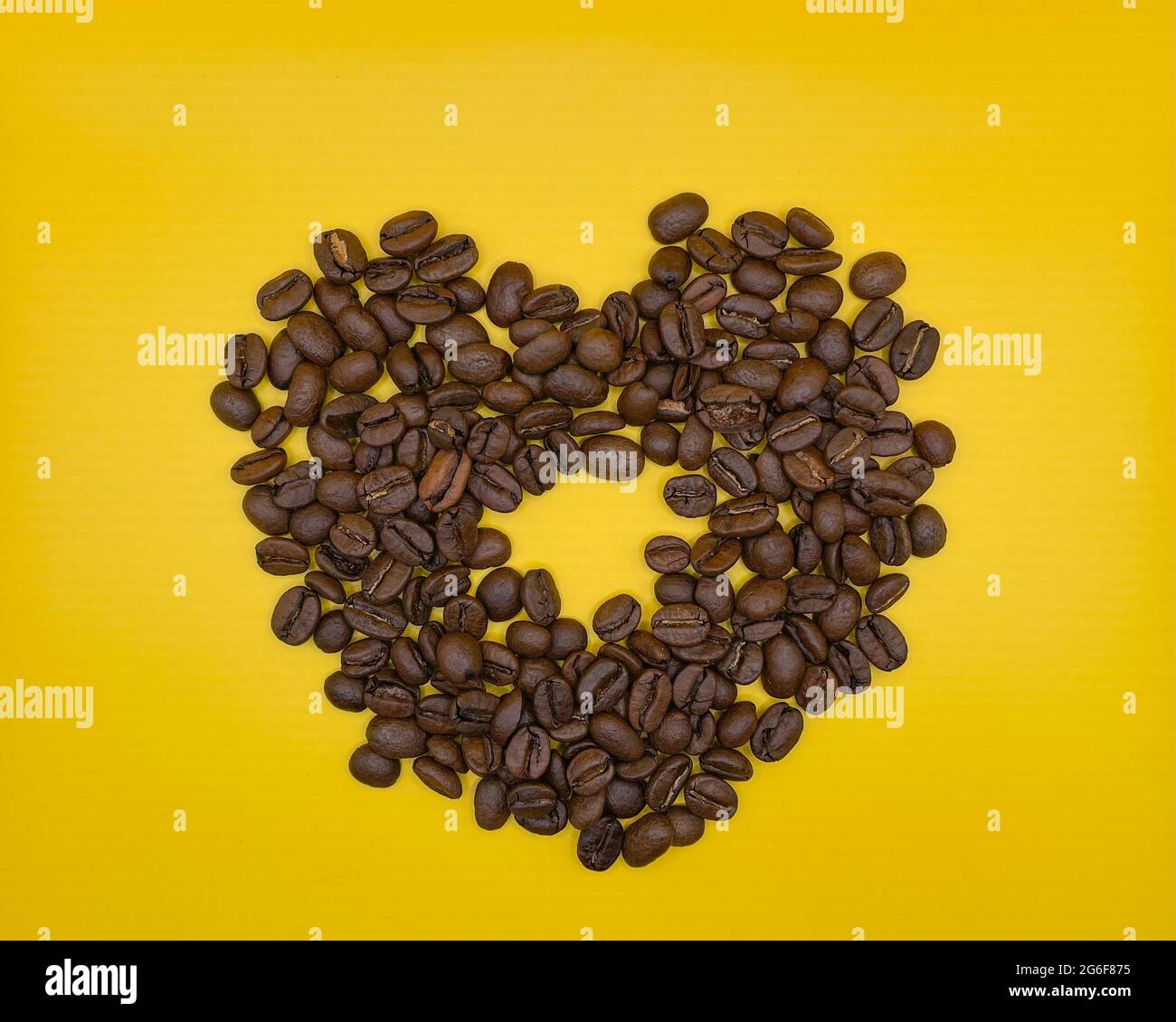 Heart coffee beans middle space on yellow background Stock Photo - Alamy