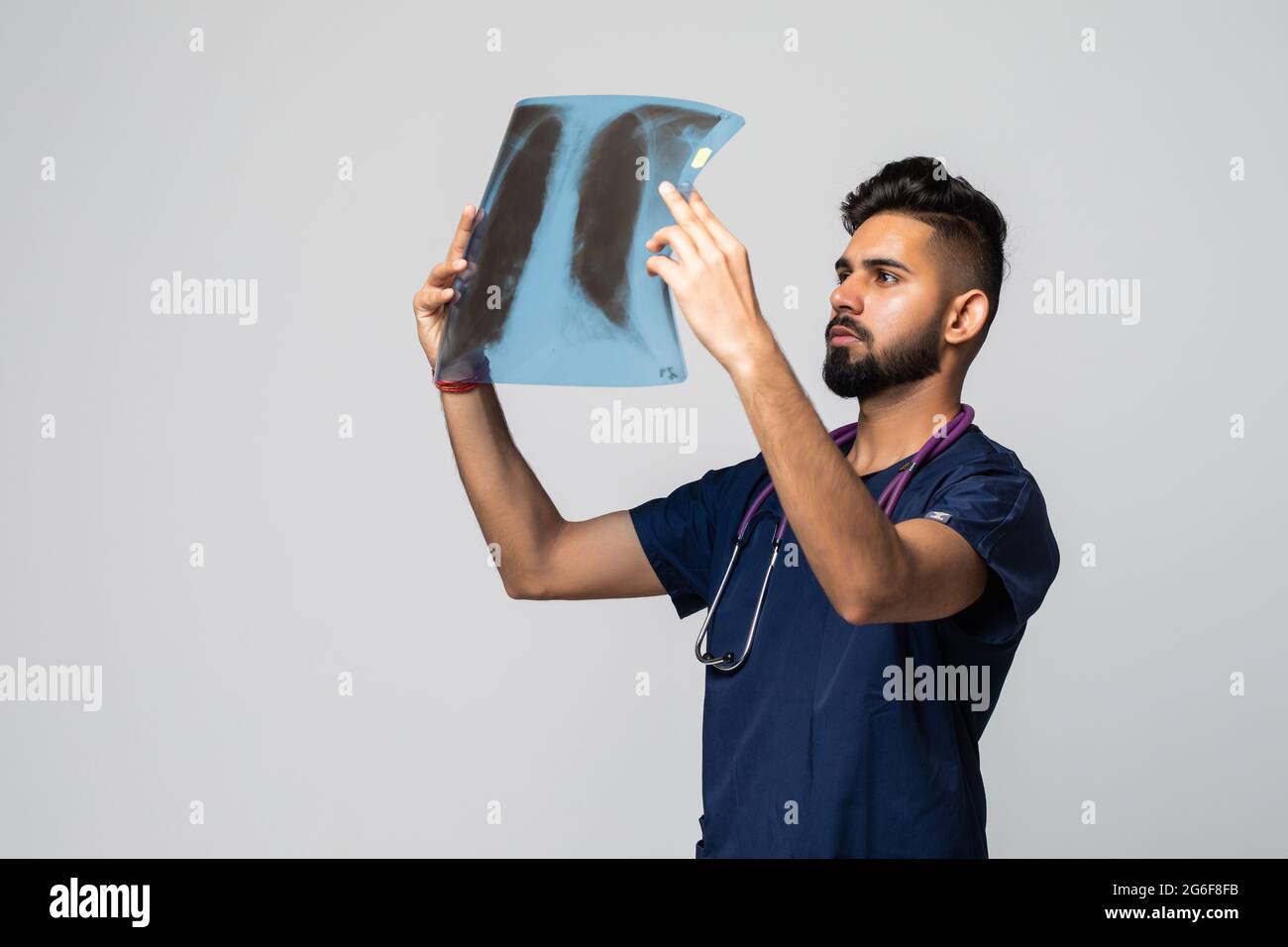 Portrait of a doctor looking at a radiography on white background Stock ...