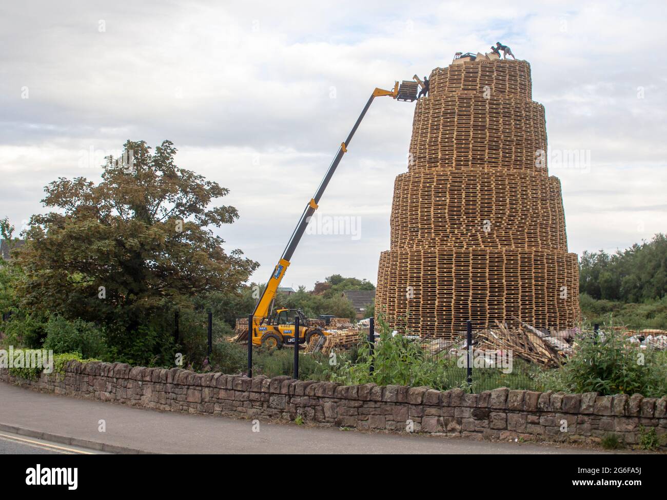 4 July 2021 Youths on top of the very tall bonfire made from thousands ...