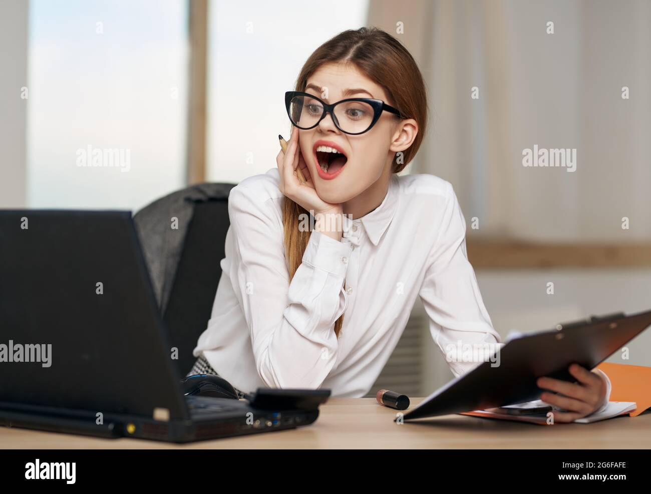 woman sitting in front of laptop in office secretary working ...
