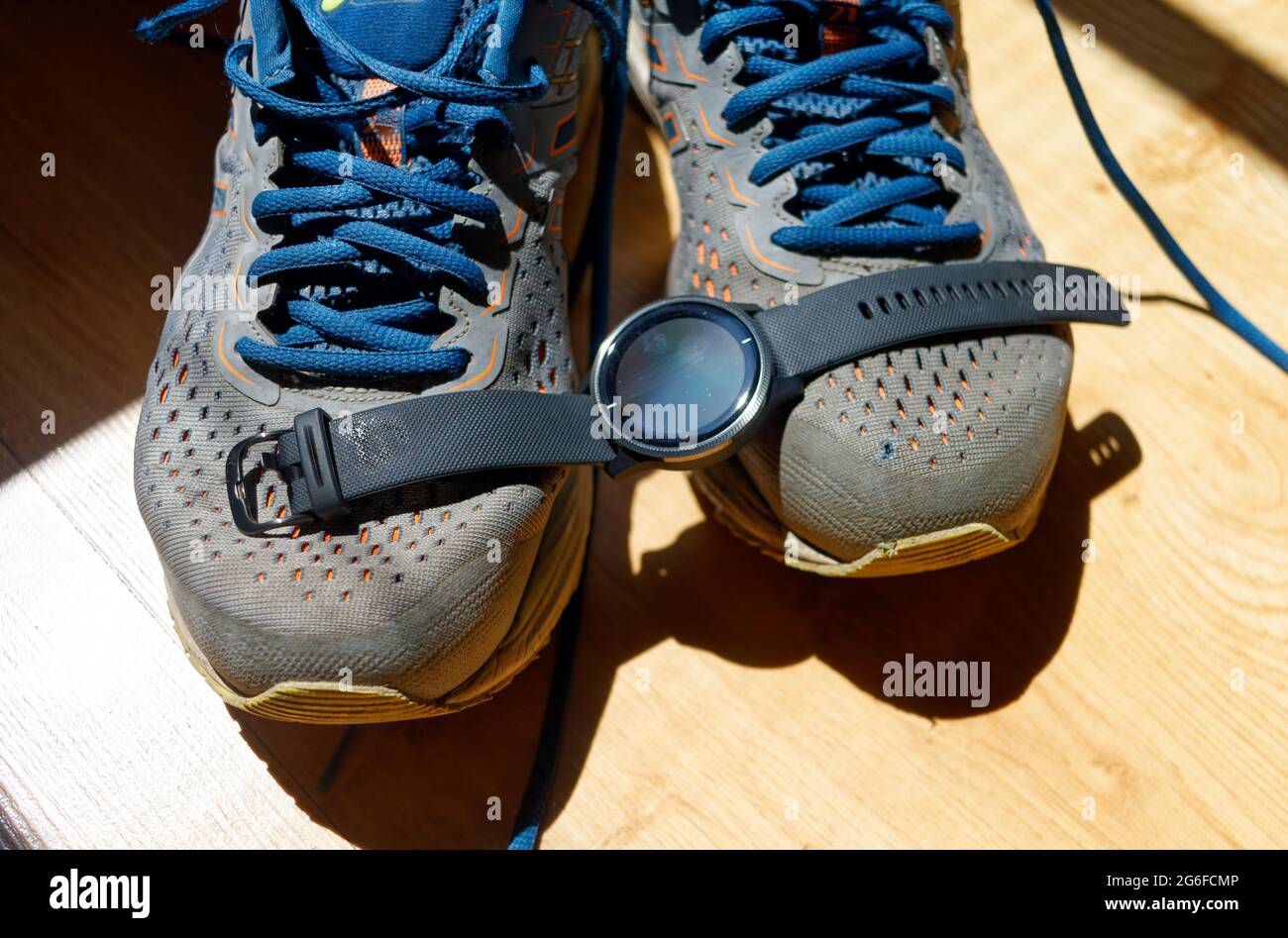 Worn running shoes and black smartwatch Stock Photo - Alamy