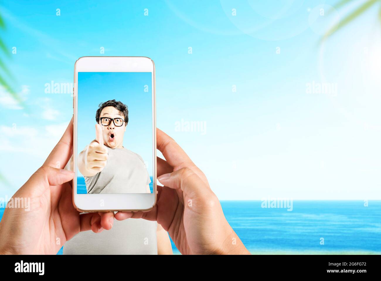 Human hand with the mobile phone taking a picture of Asian man showing ...