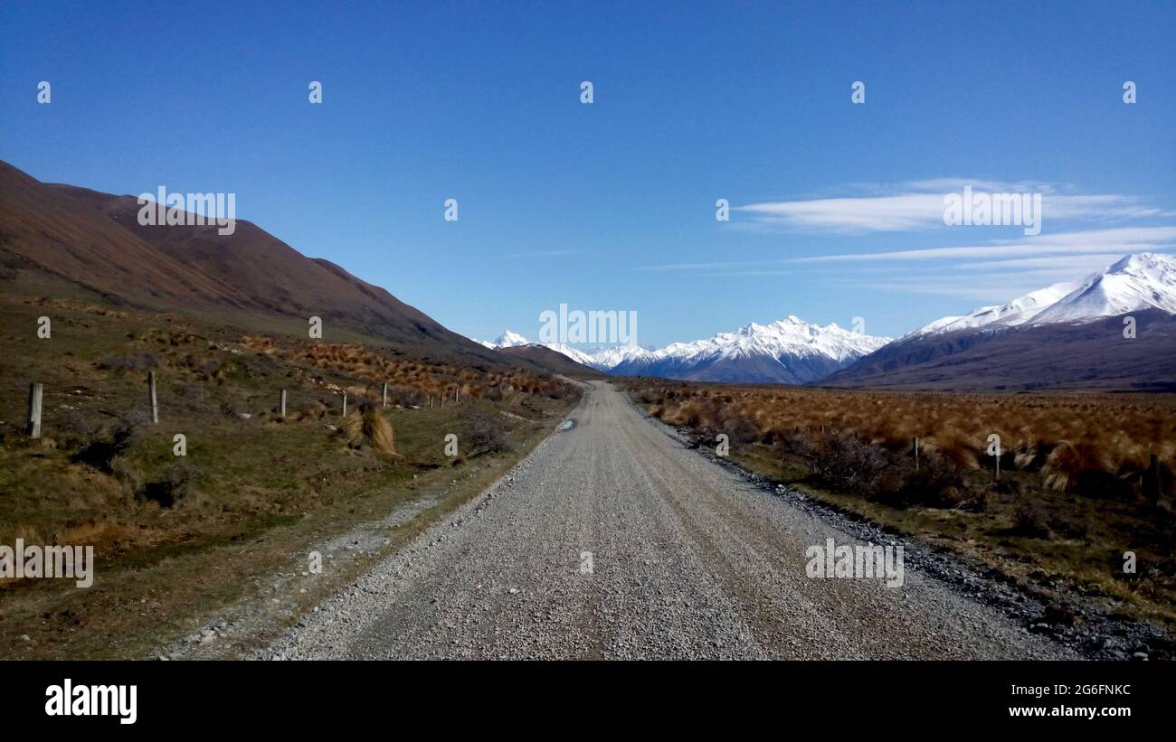 Gravel road to Mount Sunday of New Zealand with blue sky and snow ...