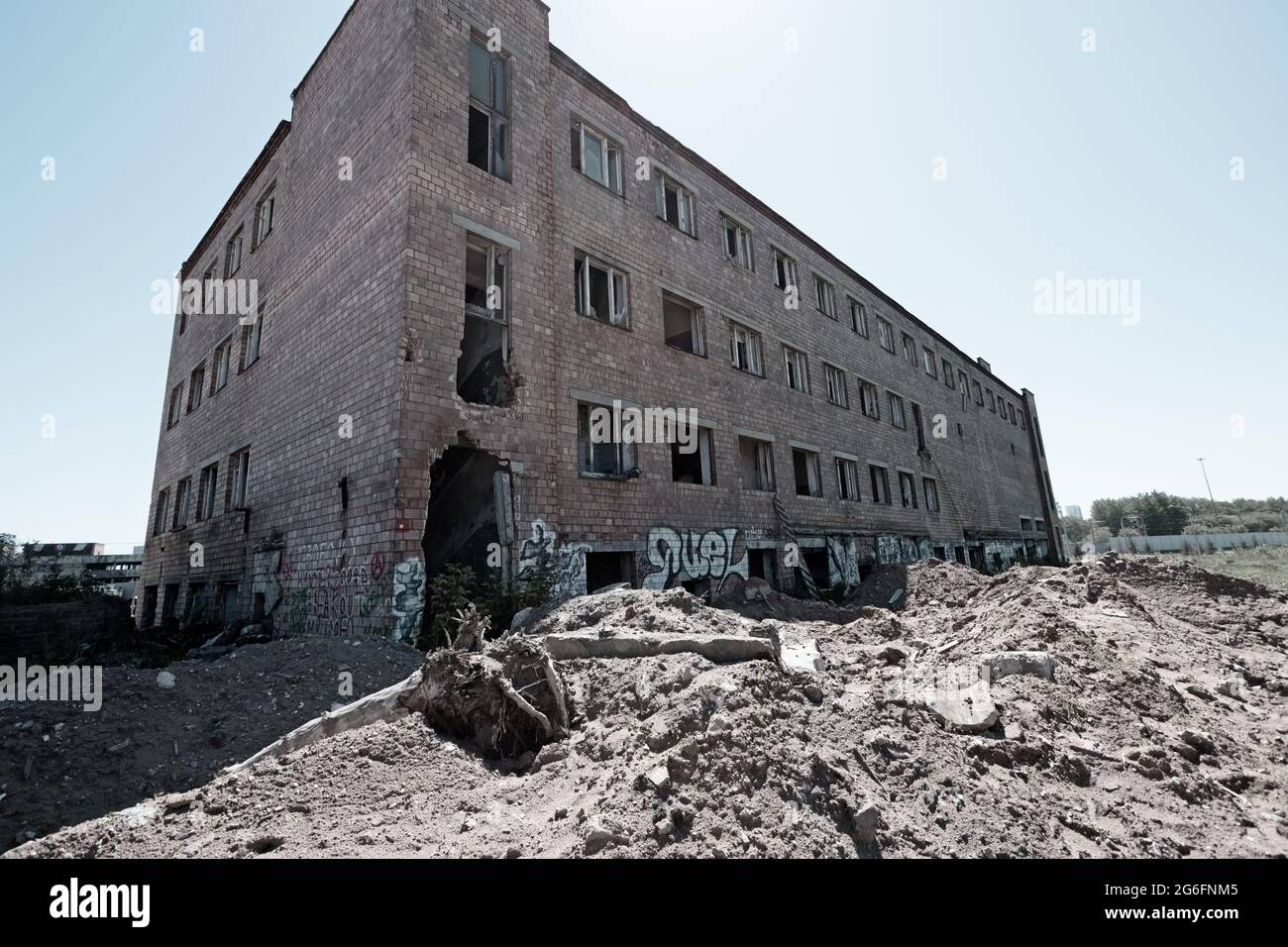 Demolished Brick Building with broken glass windows standing alone in a ...