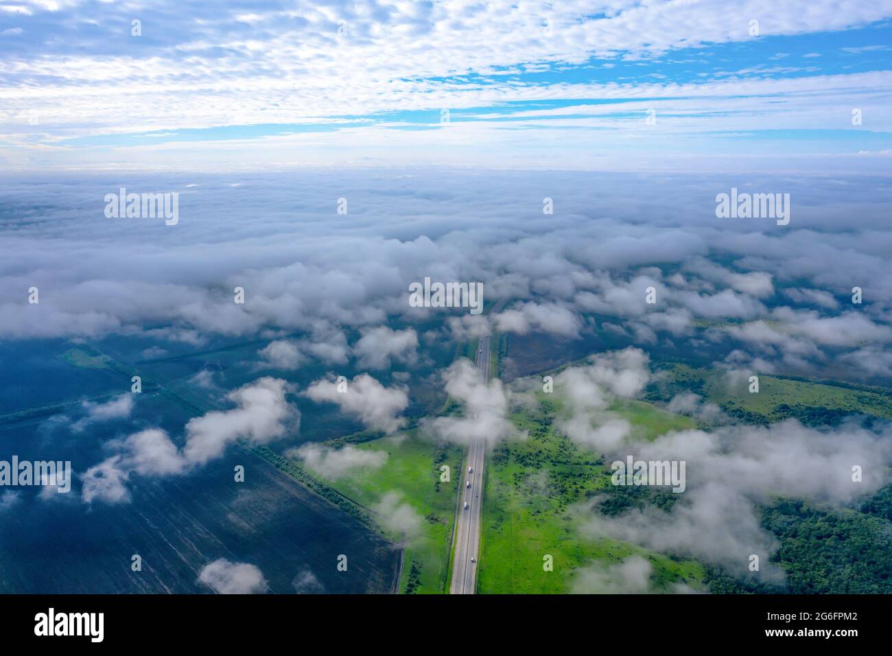 Road with cars, low clouds, shoot from a drone. Beautiful landscape ...