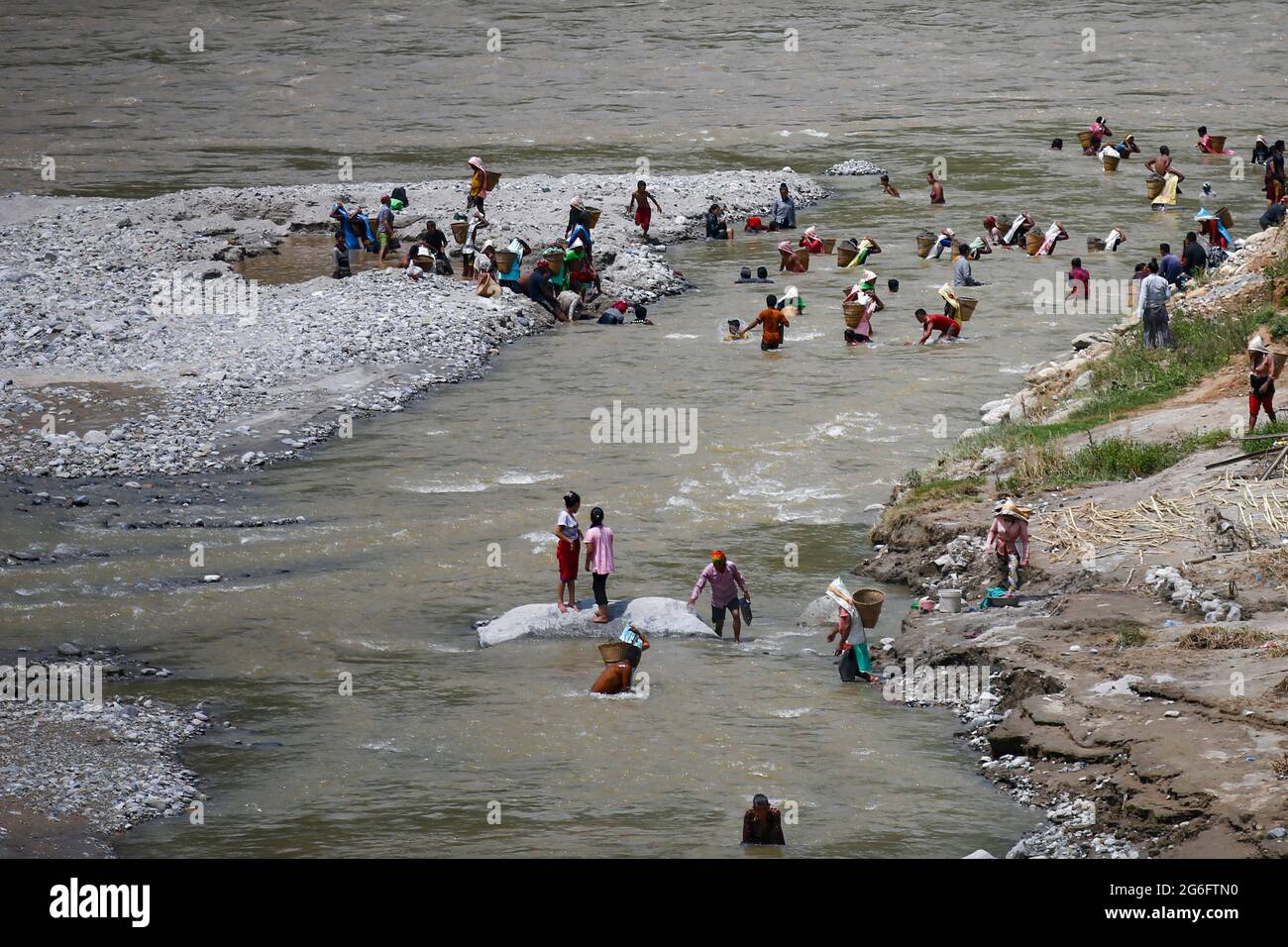 Dhading, Nepal. 6th July, 2021. Labourers ferrying sand from the ...