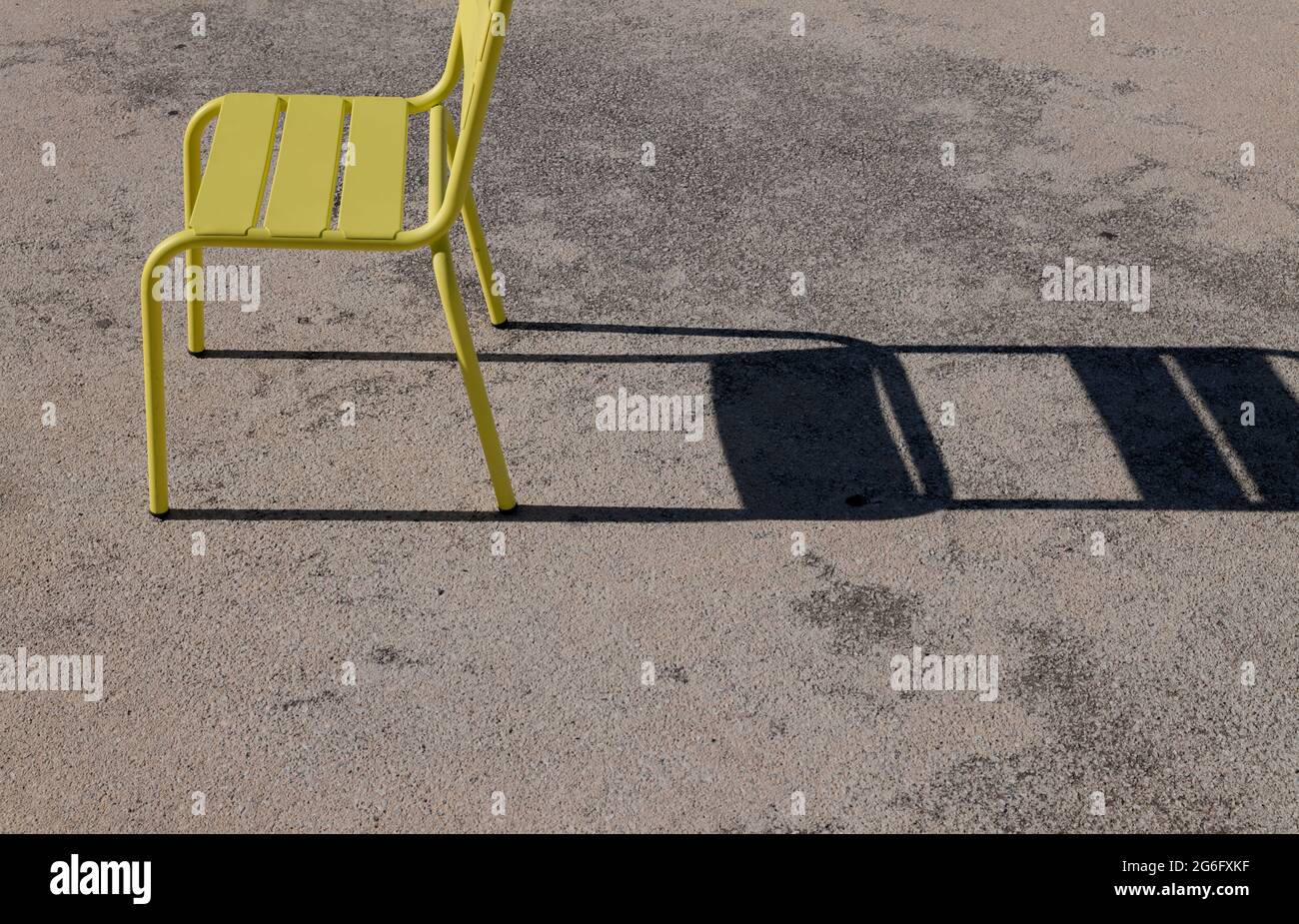 Yellow outdoor chair and shadow on cement floor Stock Photo - Alamy