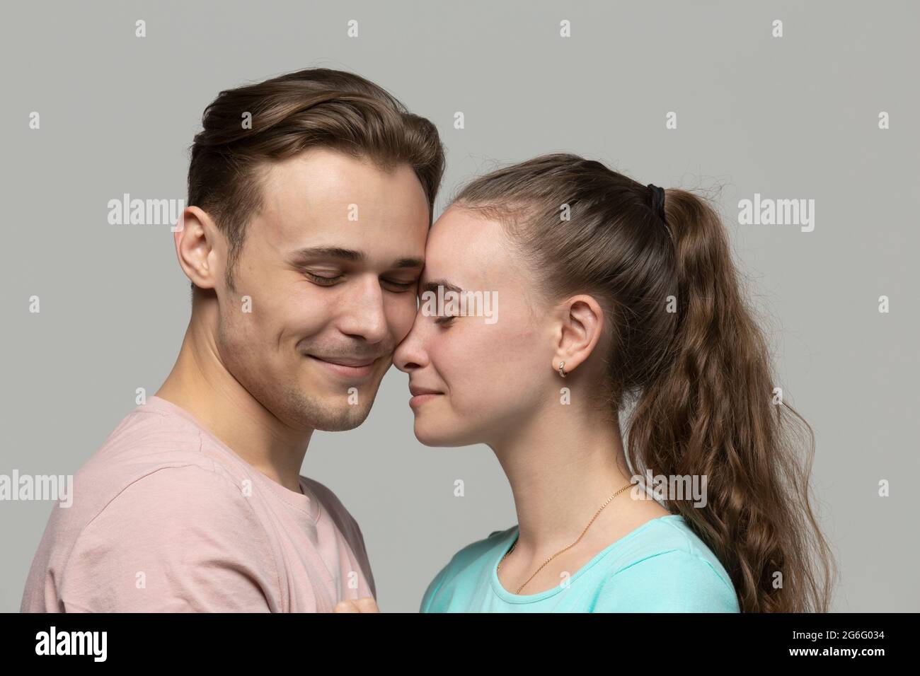 Studio portrait affectionate, tender young couple Stock Photo - Alamy