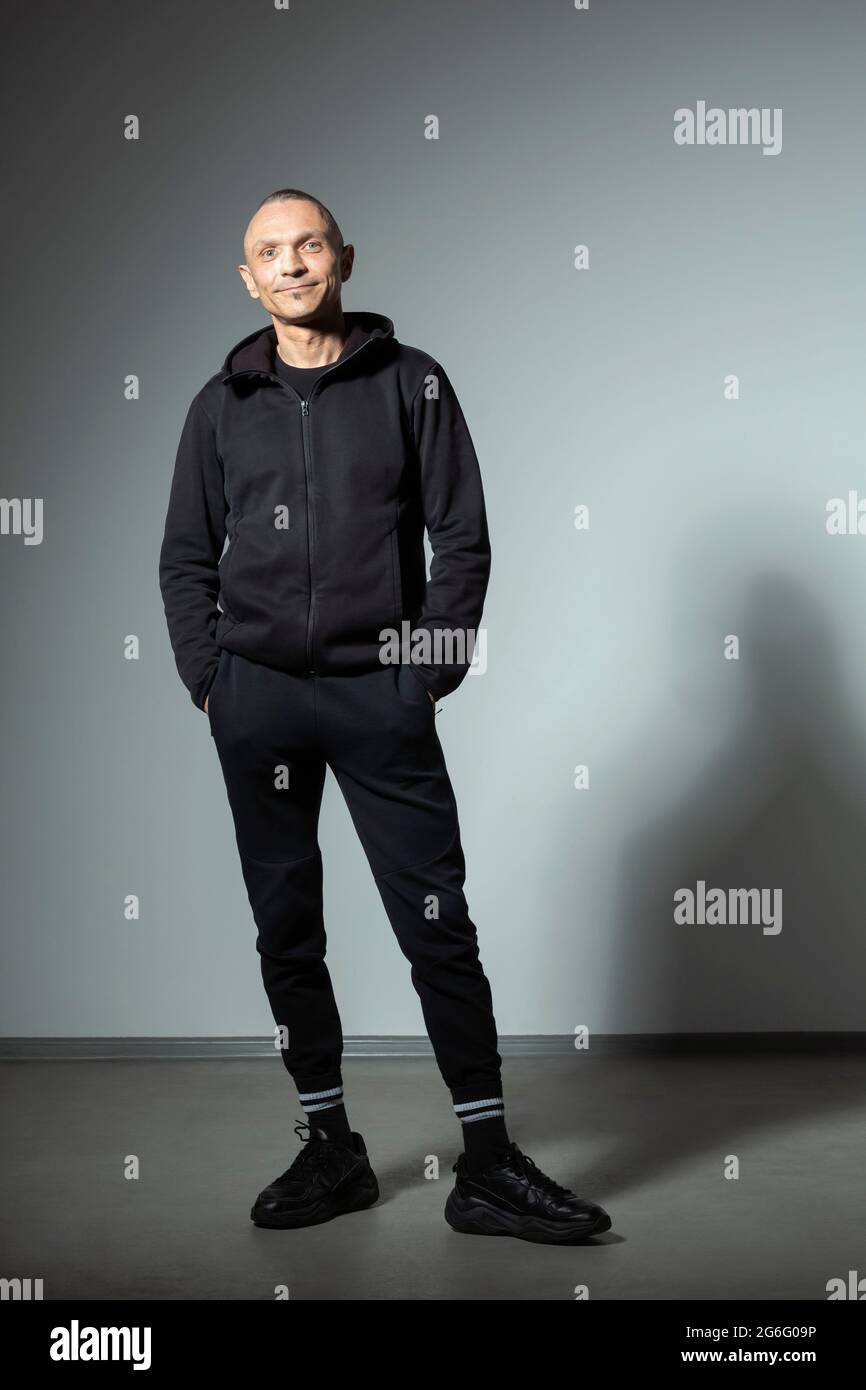 Portrait confident smiling man in black track suit Stock Photo - Alamy