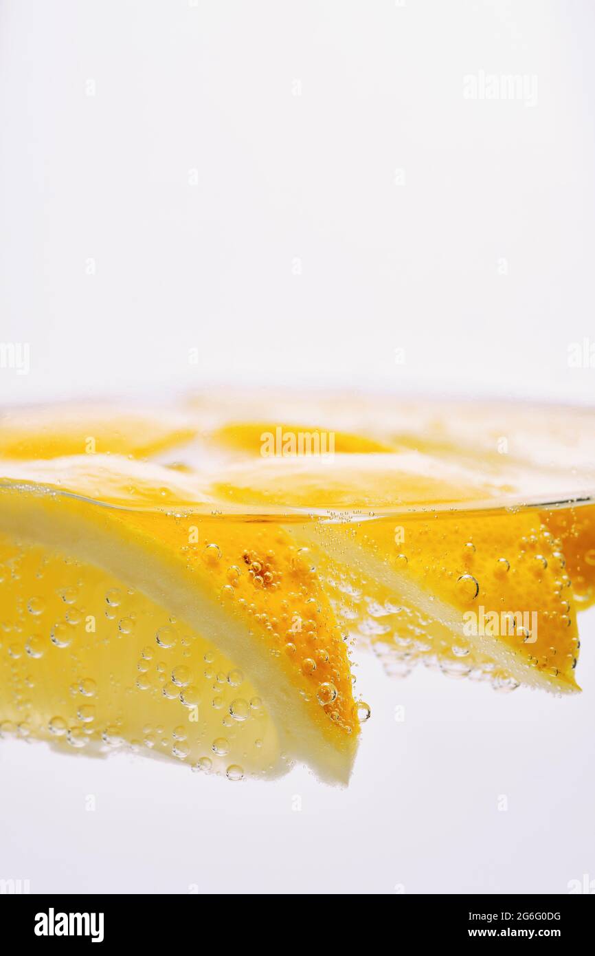 Close up lemon wedges in sparkling water Stock Photo - Alamy