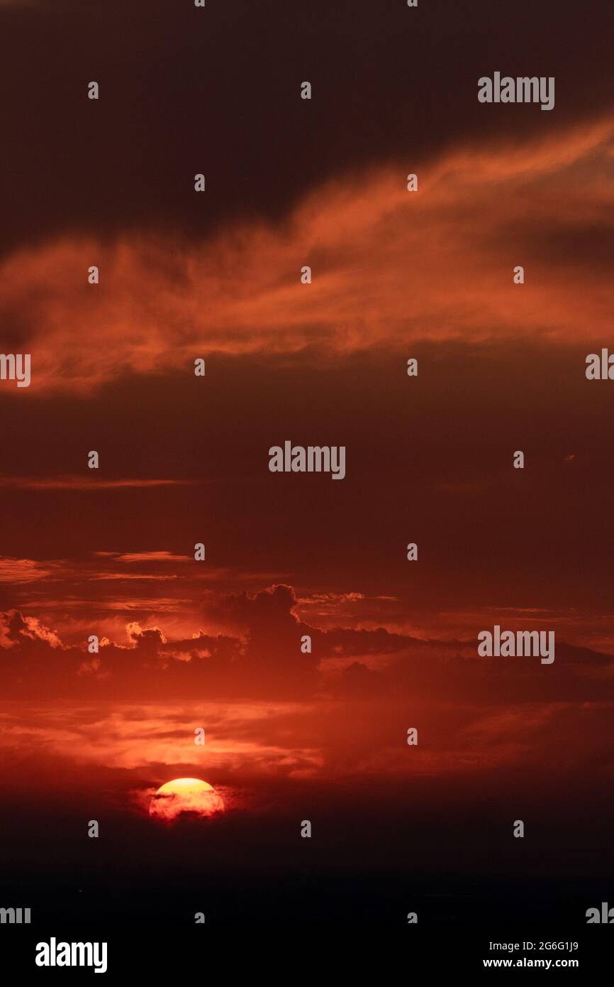 The sun sets over the horizon. Beautiful red sunset. Horizon in shadow ...