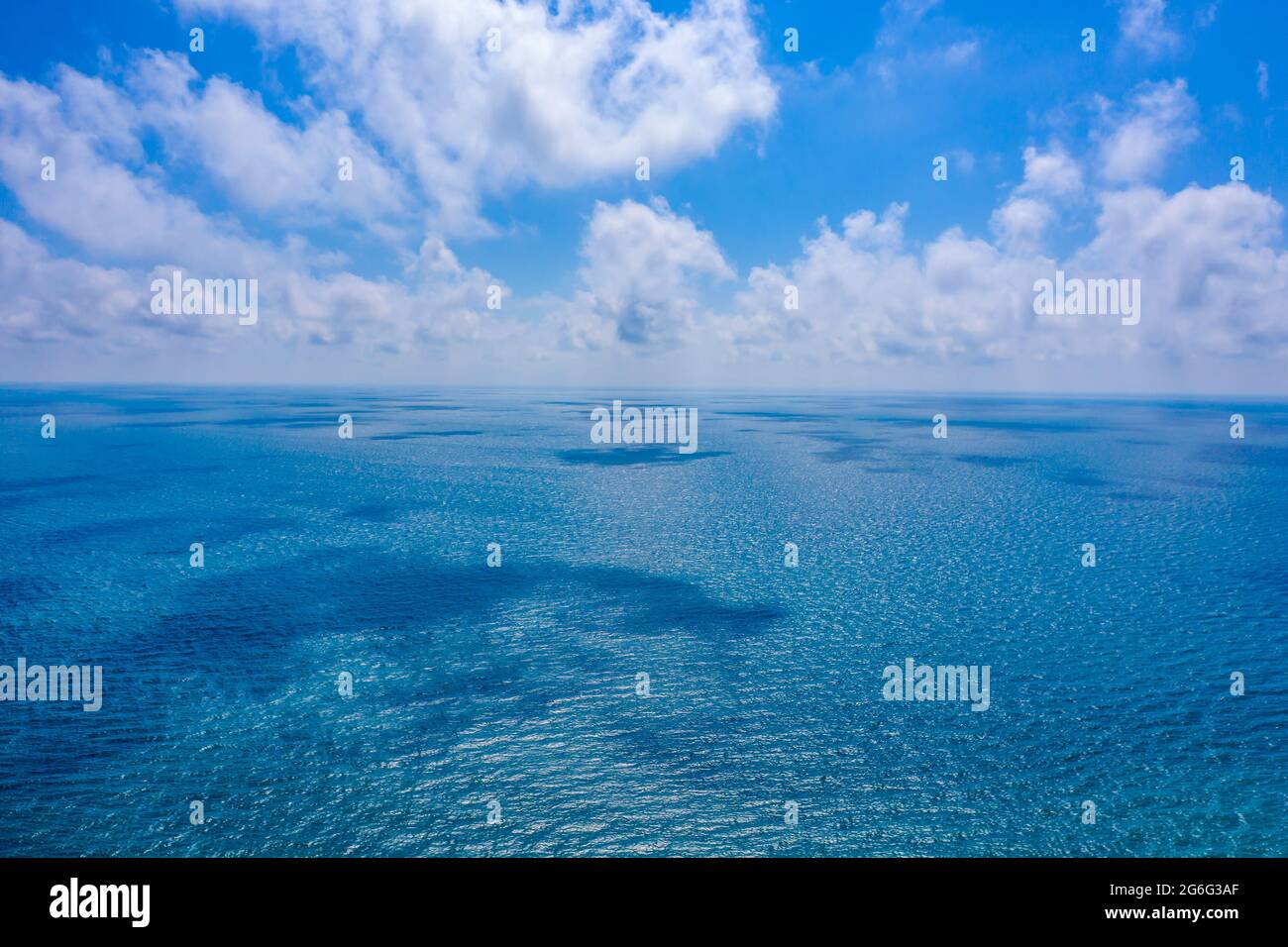 Aerial view against the backdrop of blue sea water and sun reflections ...