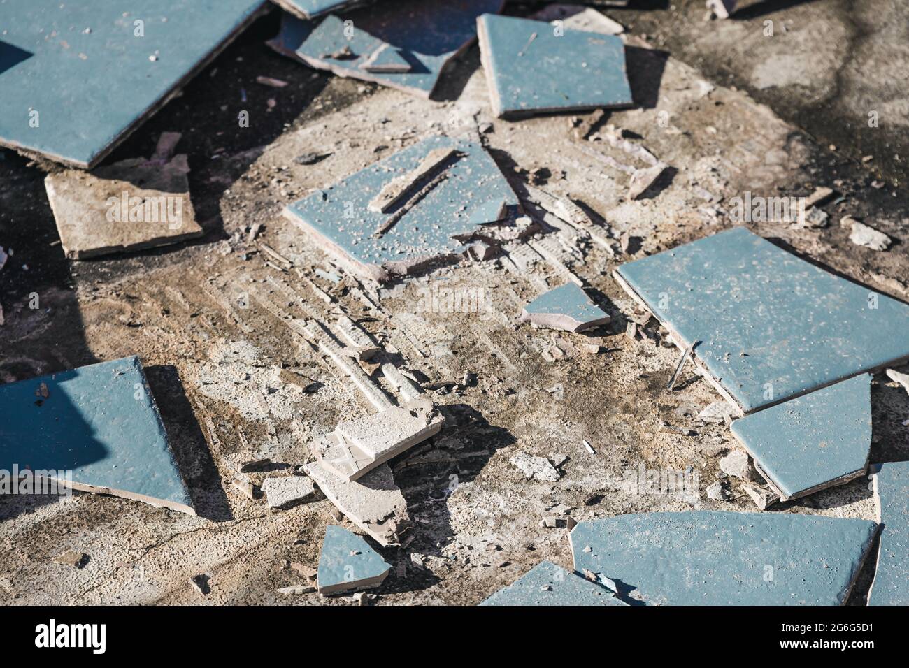 blue outdoor tiles getting ripped up to reveal concrete paving ...