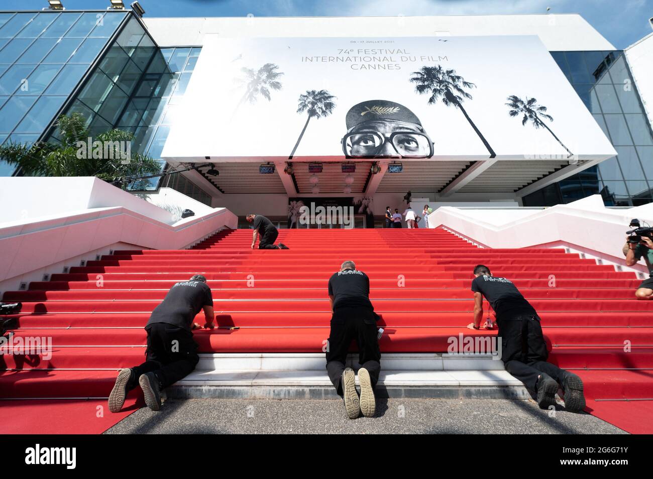 Workers install the red carpet in front of the main entrance of the ...