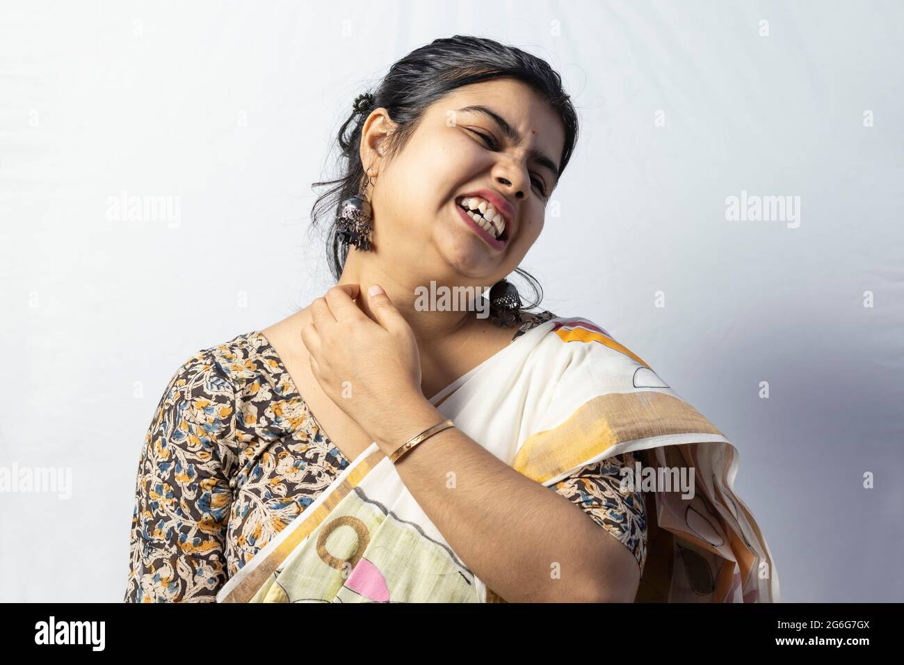 Isolated on white background an Indian woman in saree itching her neck ...