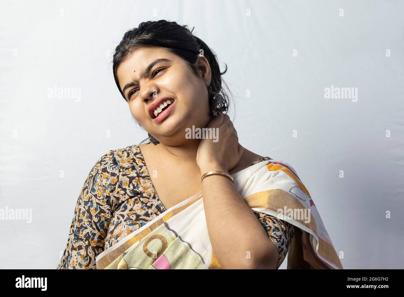Isolated on white background an Indian woman in saree holding neck ...