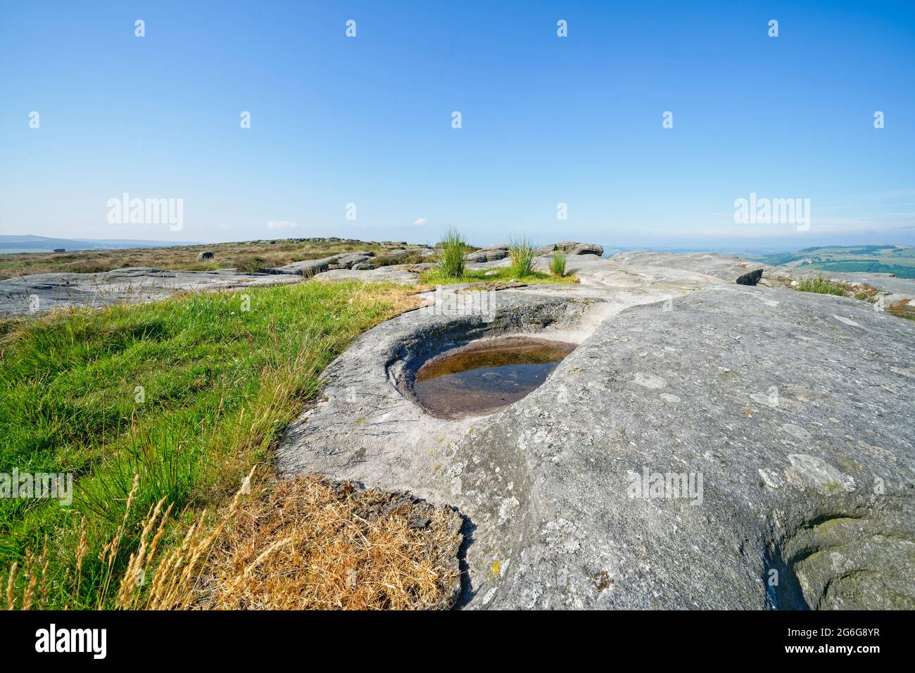Weathered gritstone rocks collecting rainwater in hollows on Baslow ...