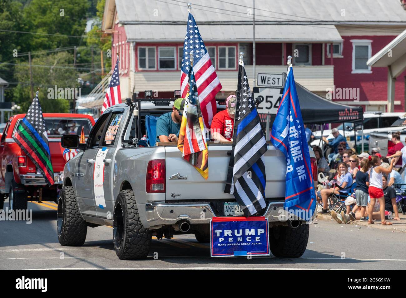 A pickup truck with various flags and a Trump-Pence election sign ...