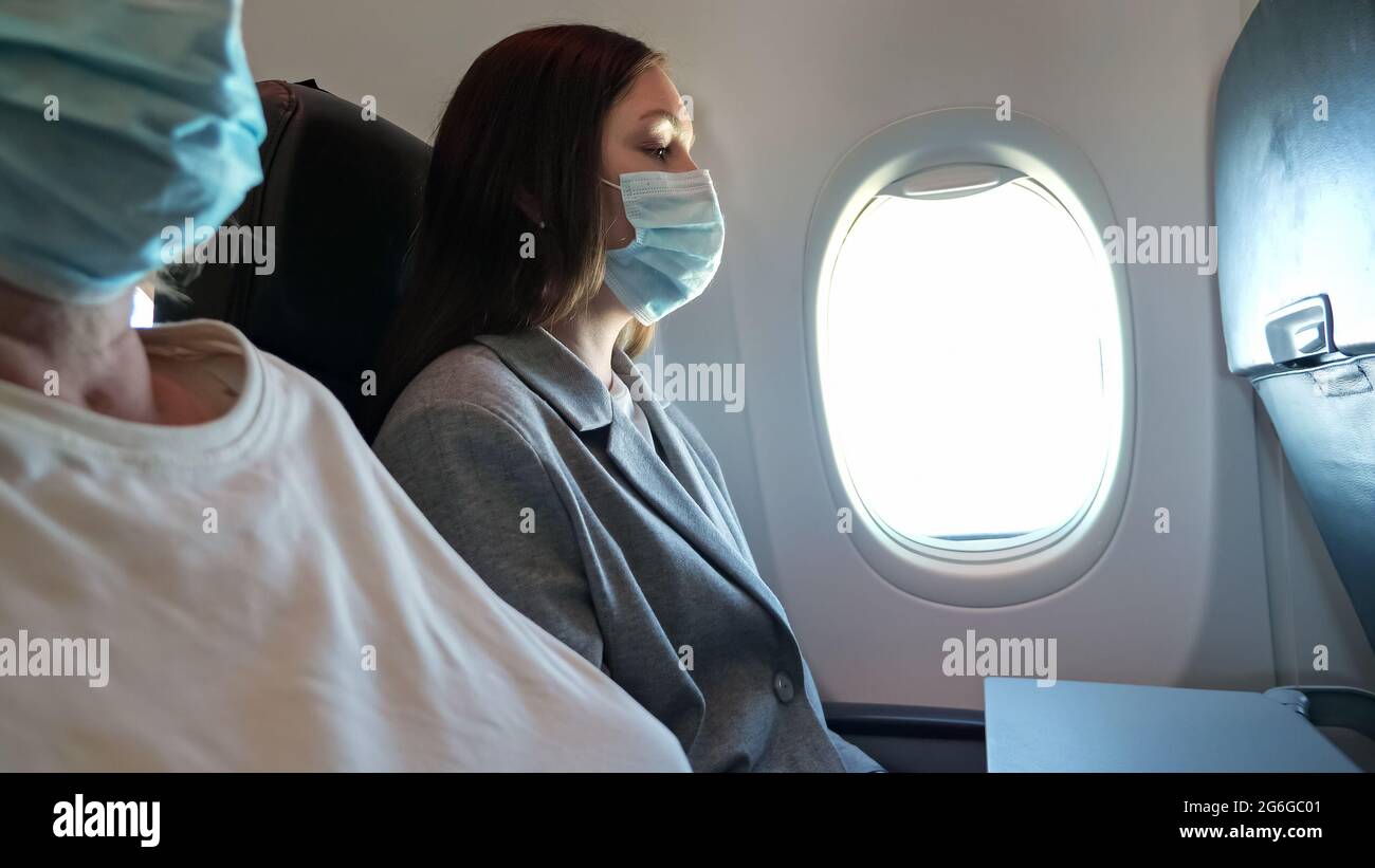 Airplane passengers are flying in medical masks Stock Photo - Alamy