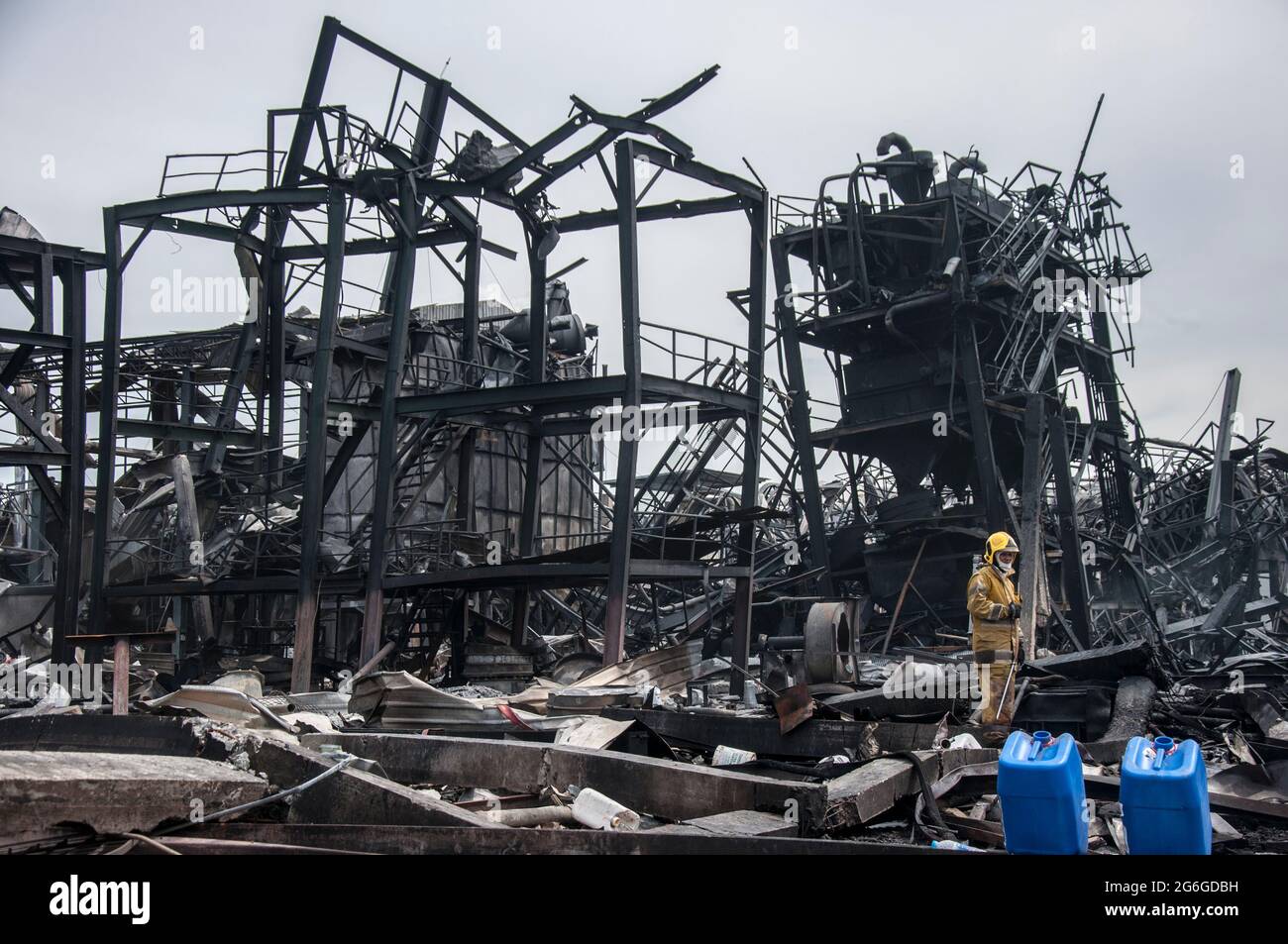 A Thai firefighter walks next to damaged structures caused by an ...