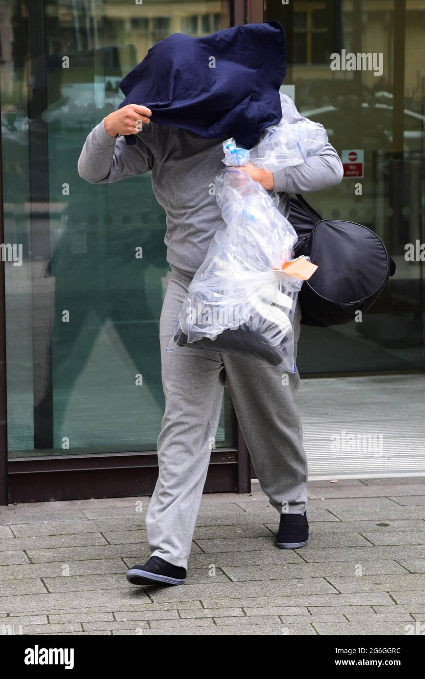 Jonathan Chew, 24, covers his head outside Westminster Magistrates ...