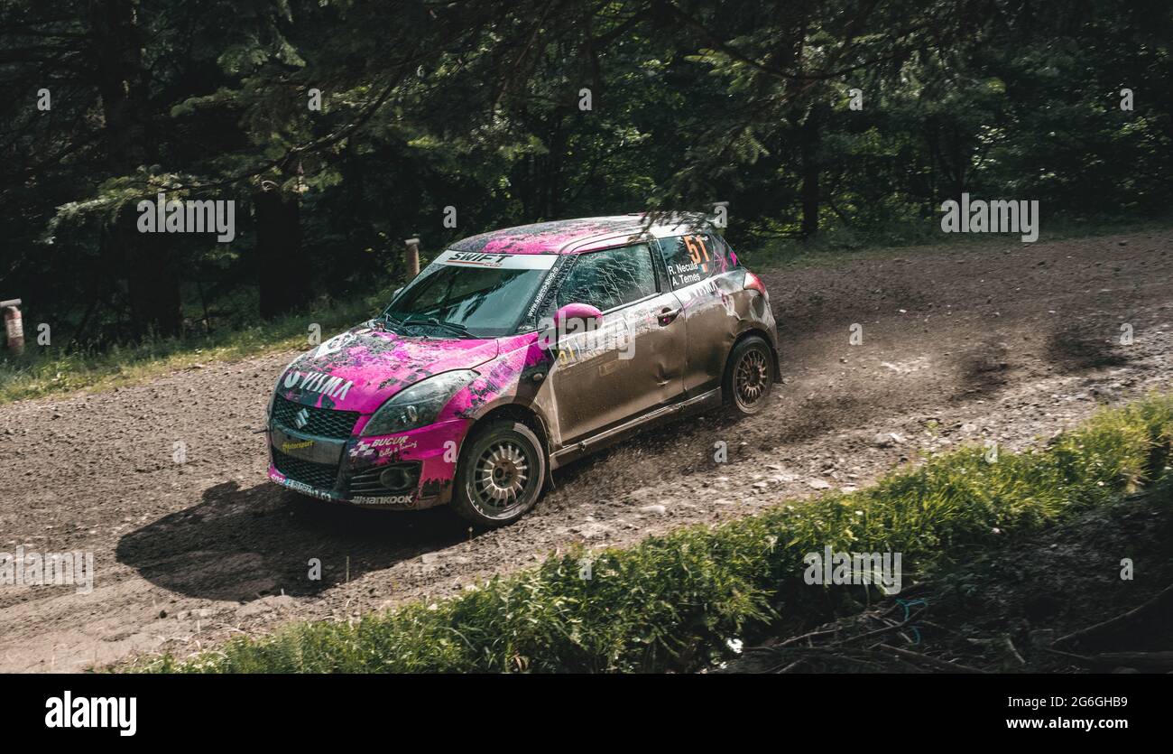 Action shot of rally car during a competition on muddy forst tracks ...
