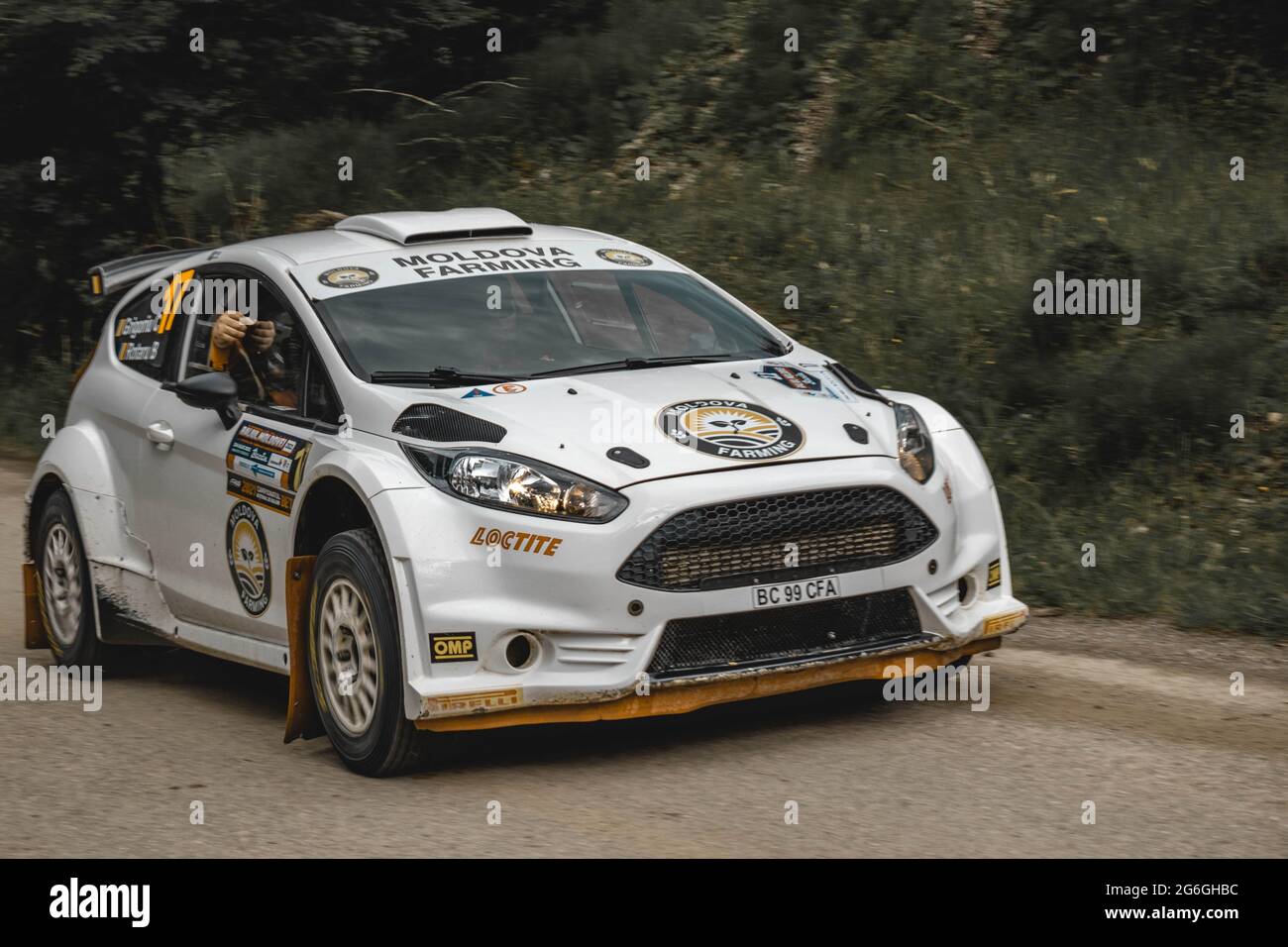 Action shot of rally car during a competition on muddy forst tracks ...