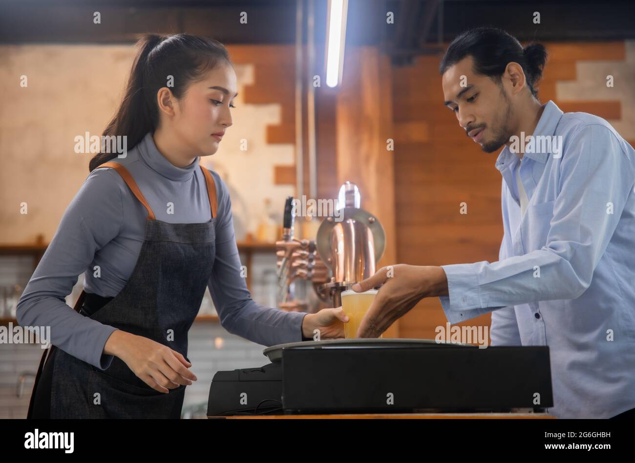 Asian girl, waitress or staff serve craft beer, beverage to customer ...