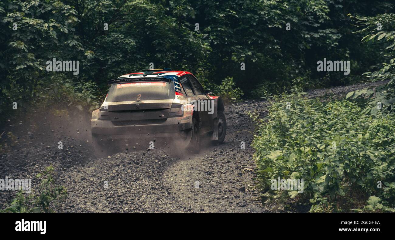 Action shot of rally car during a competition on muddy forst tracks ...
