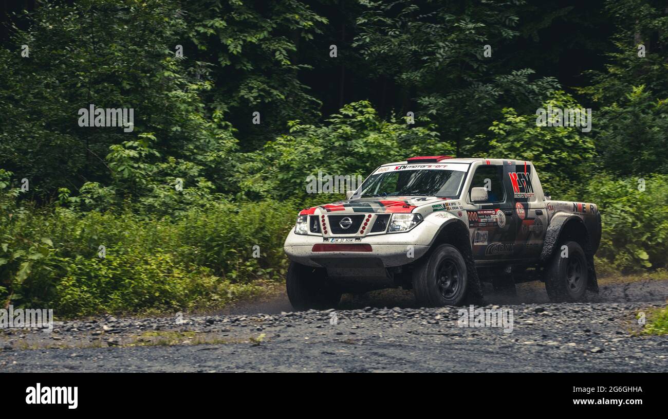 Action shot of rally car during a competition on muddy forst tracks ...