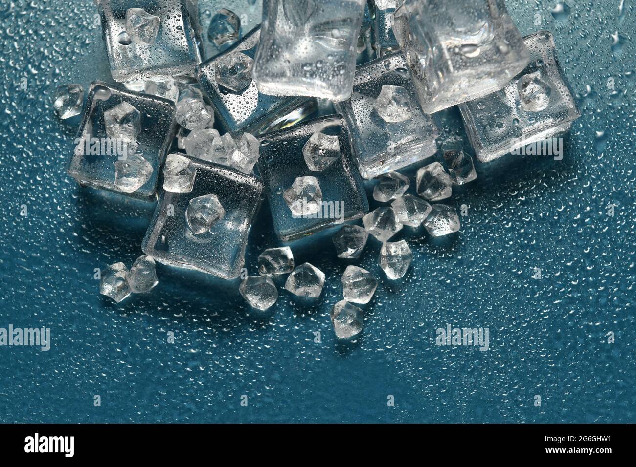 ice stone on reflective surface of background with drops, idea of a ...