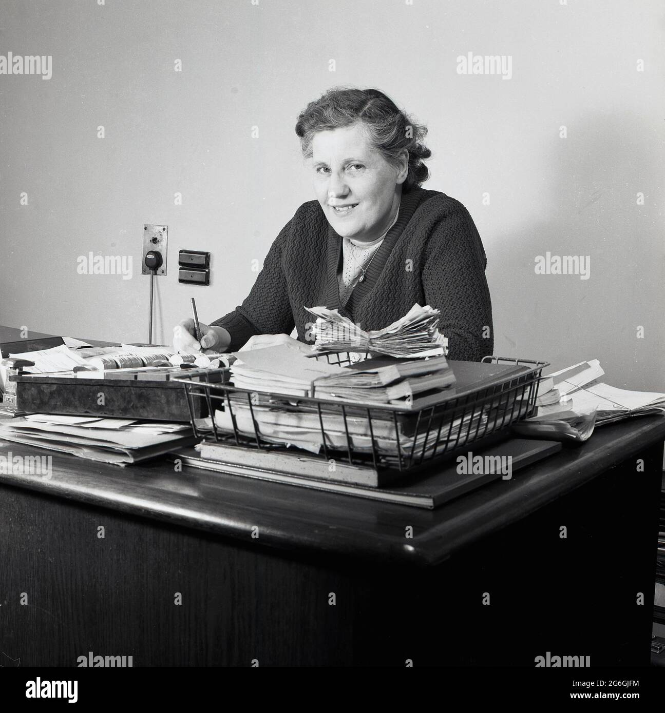 1970s, historical, female bookkeeper at her desk, with paperwork and ...