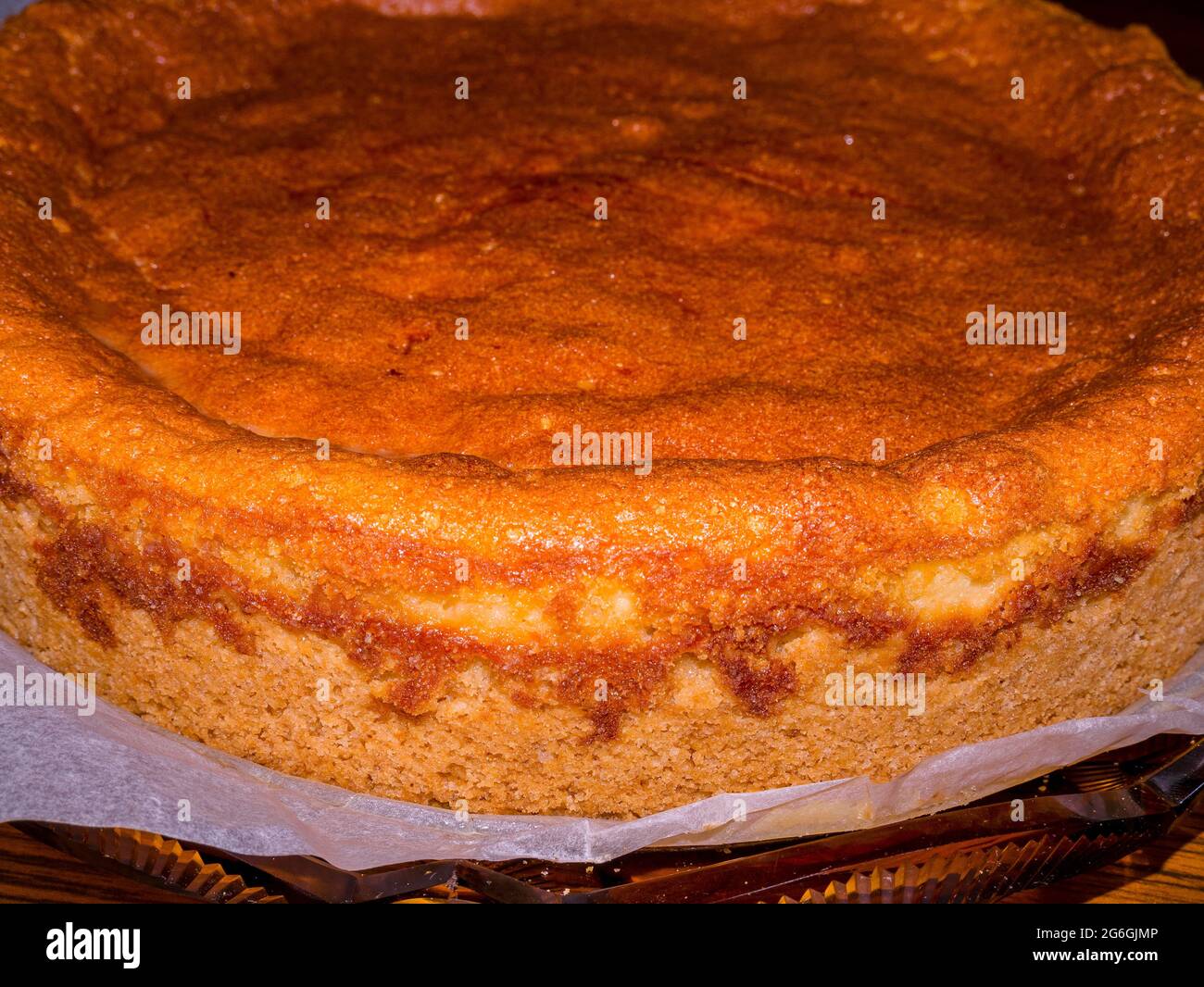 Side view of homemade freshly baked stuffed cheesecake on a glass tray ...