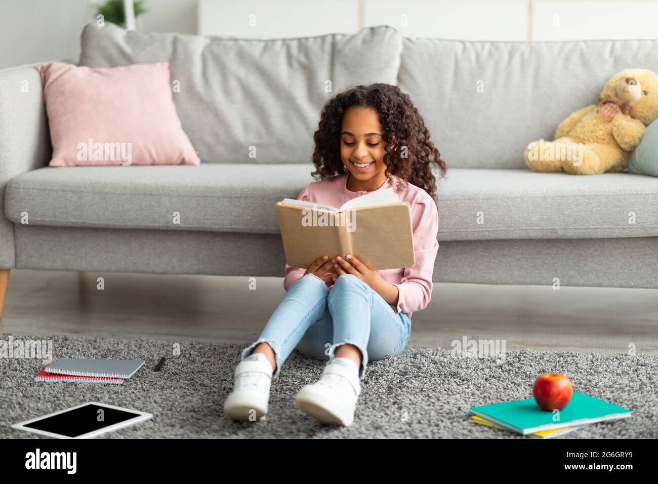 Youth and literature. Smiling african american gen z girl holding and ...