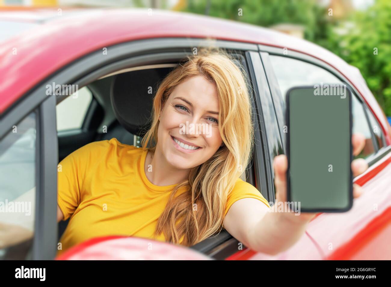 Young woman driving a car shows a smartphone screen Stock Photo - Alamy
