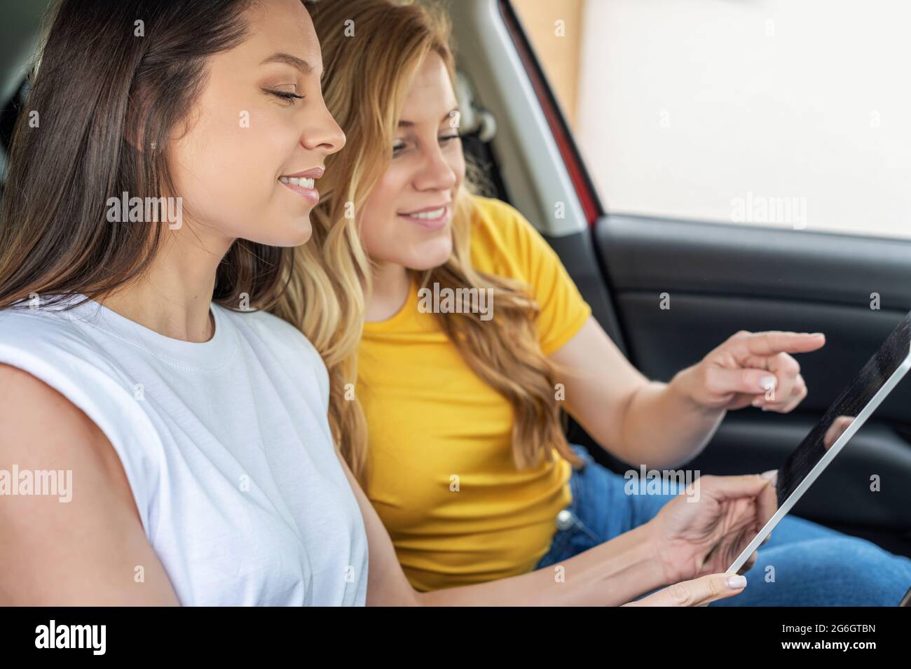 Young women in the car use the tablet Stock Photo - Alamy