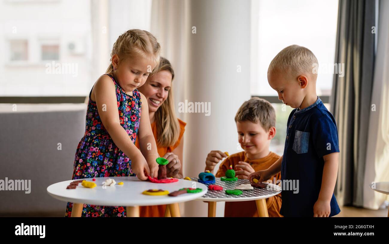 Nursery children having fun and playing with teachers Stock Photo - Alamy
