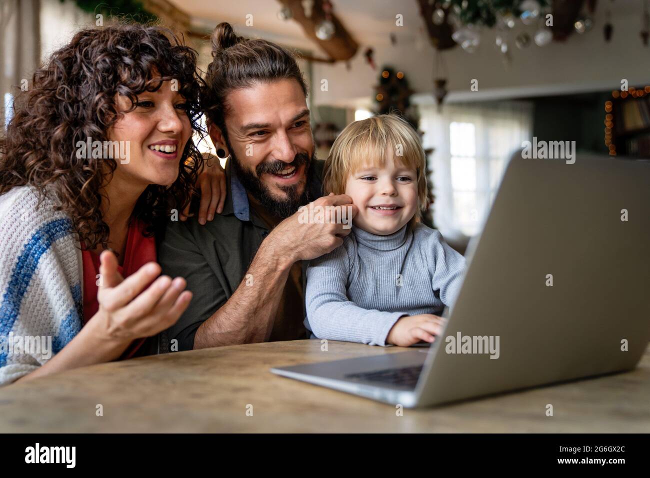 Happy family with kid having fun using laptop together, watching ...