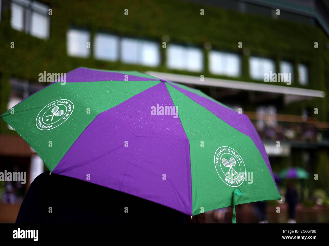 A Wimbledon branded umbrella can be seen during a rain delay on day ...