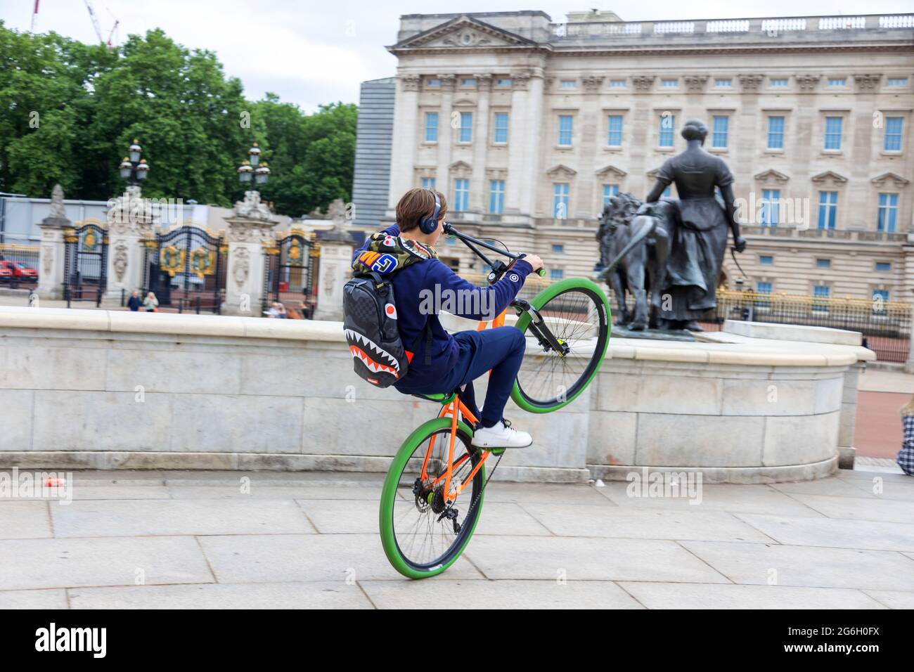 A teenage cyclist pulling a wheelie in front of Buckingham Palace in ...