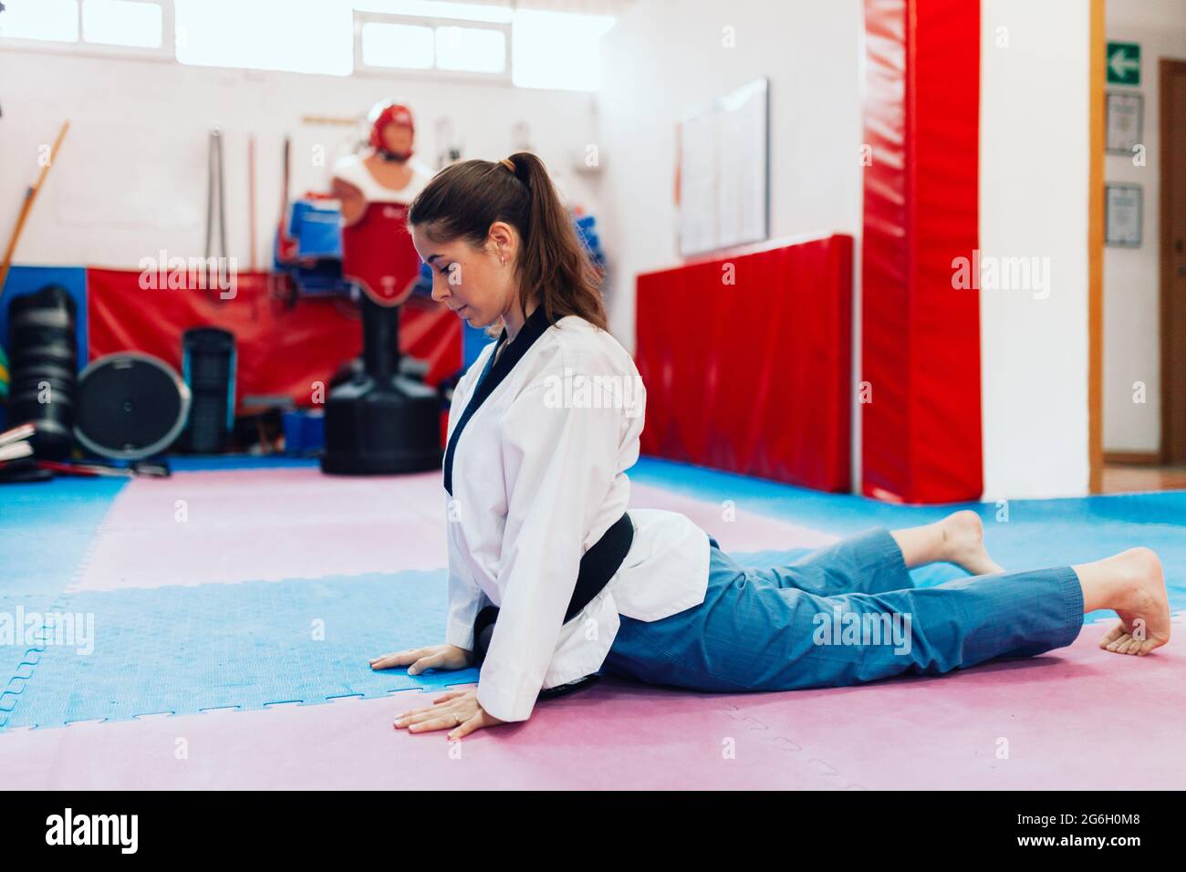 Young woman stretching in a dojo wearing taekwondo dobok Stock Photo ...