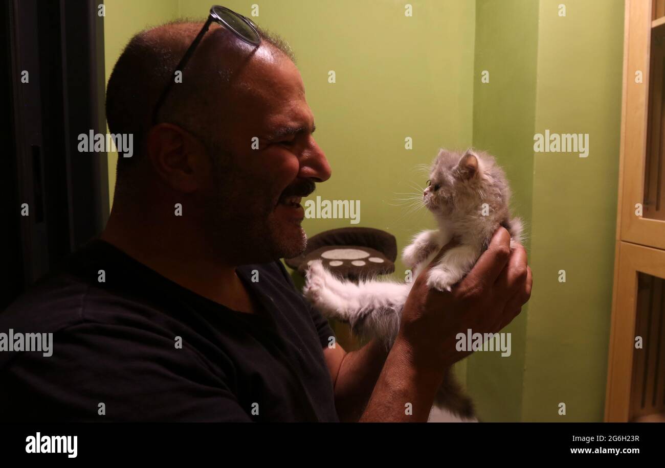 Ramallah. 9th June, 2021. George Ghattas plays with a cat inside the ...