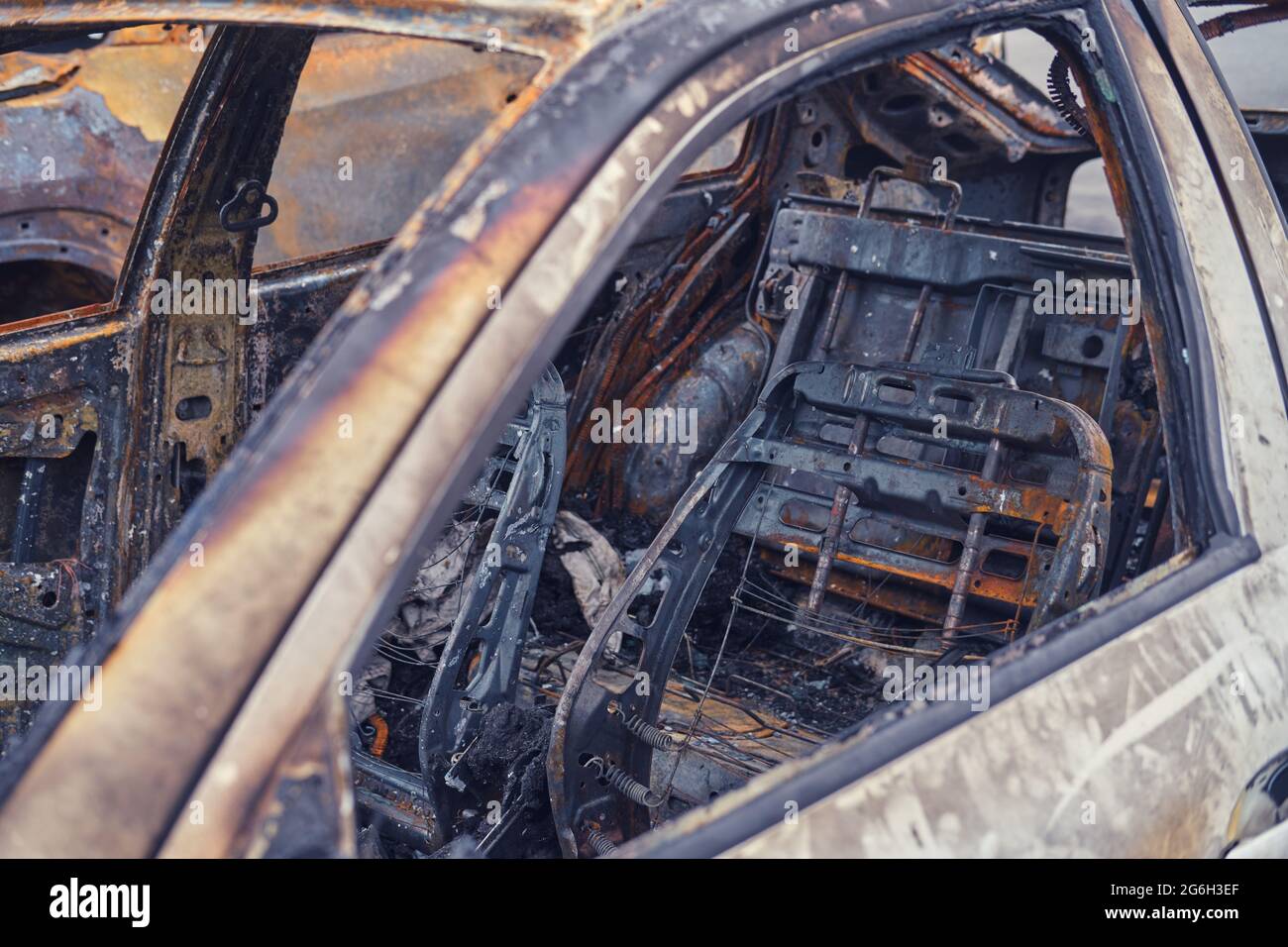 Burnt-out rusty cars on a city street, vandalism. Setting fire to cars ...