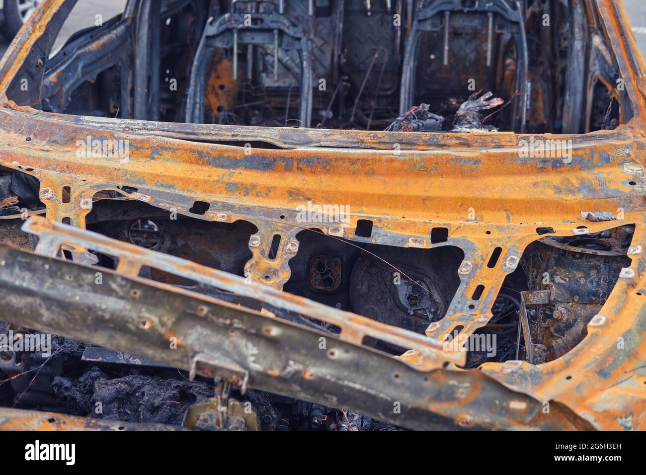 Burnt-out rusty cars on a city street, vandalism. Setting fire to cars ...