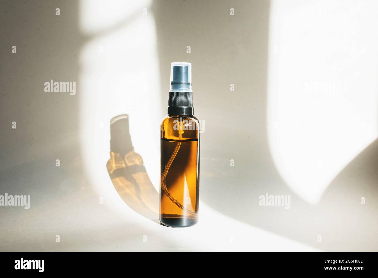 Cosmetic bottle made of dark amber glass on a white background with a ...