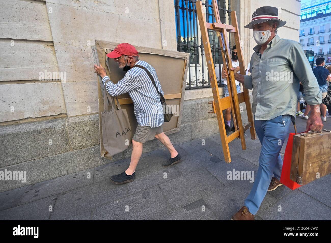 Painter, Antonio Lopez seen carrying the canvas of the painting he left ...