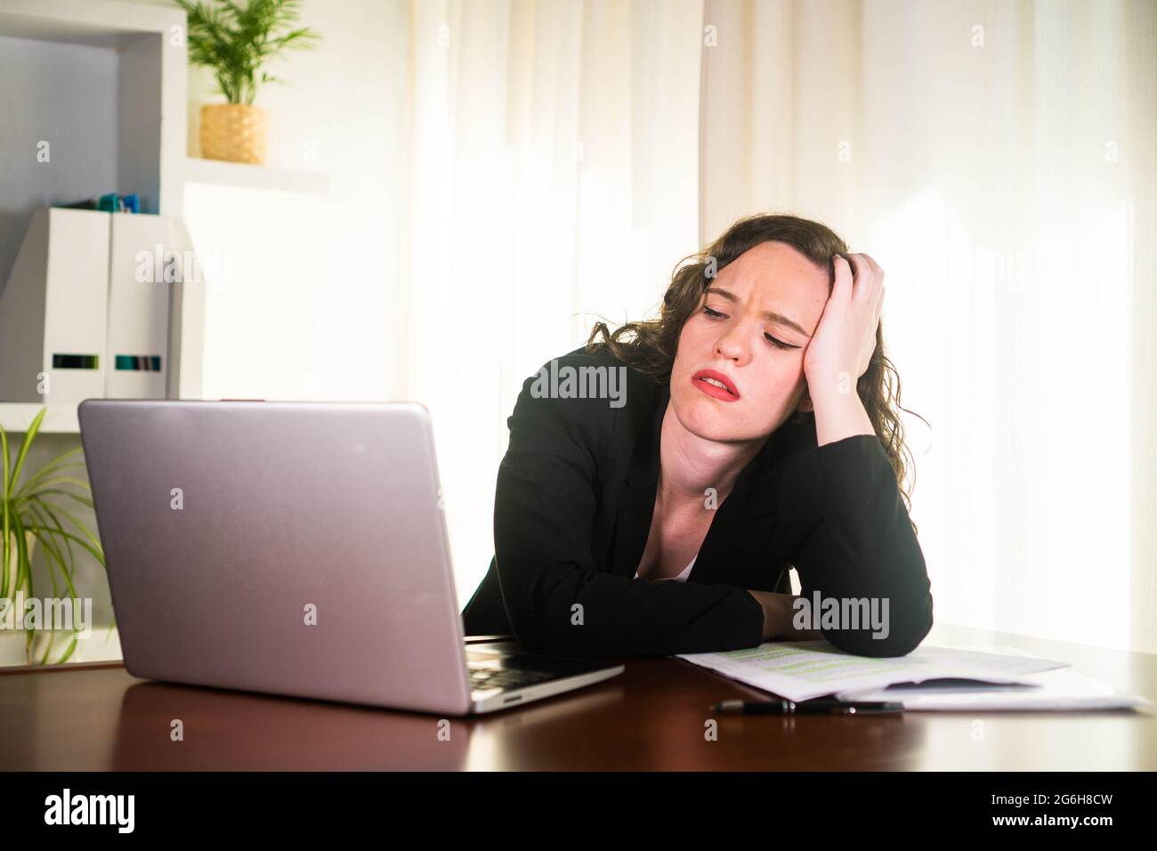Business woman working at her computer and stressed out in the office ...