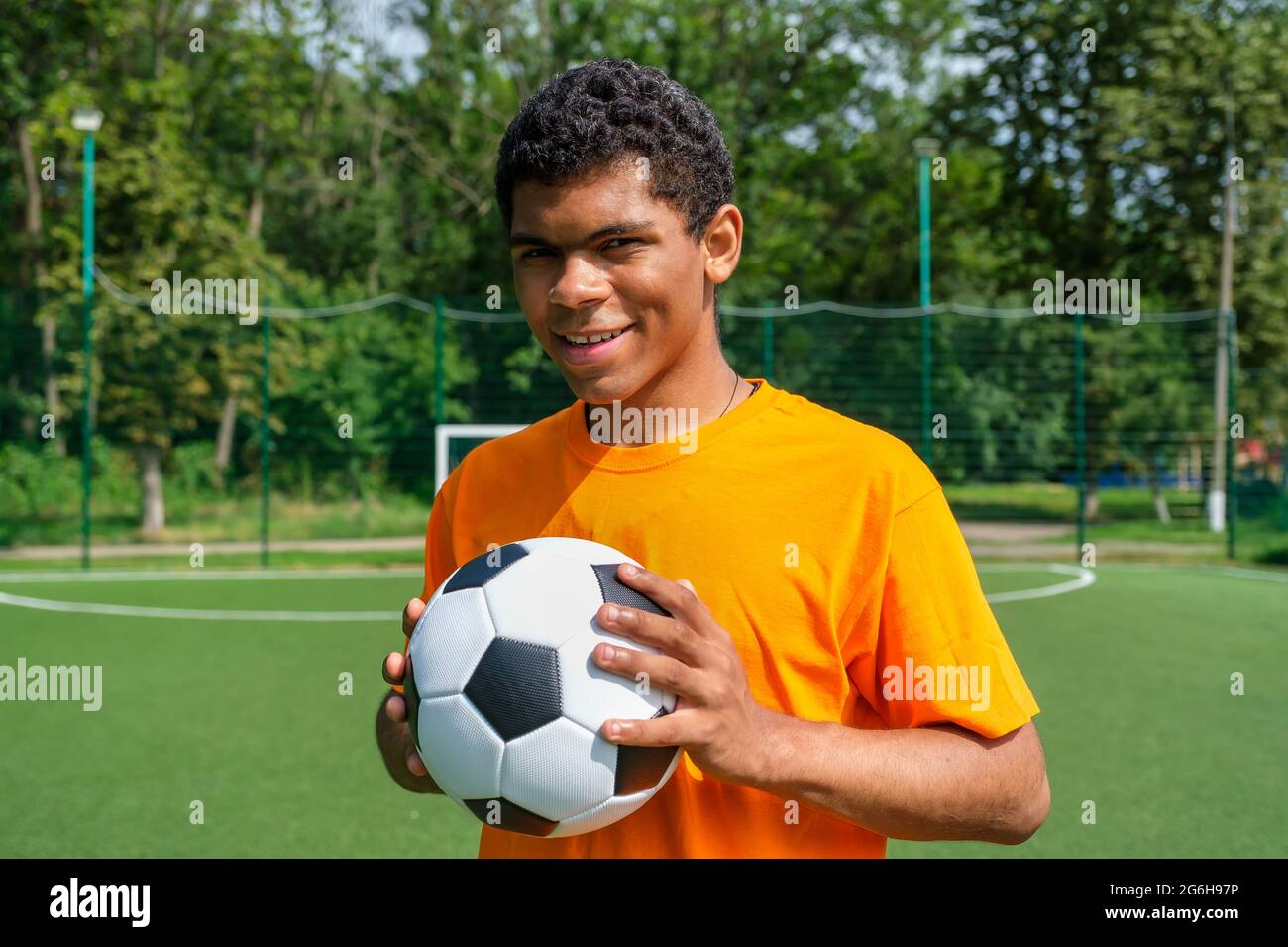 Brazilian man holding soccer ball while standing on sports court Stock ...